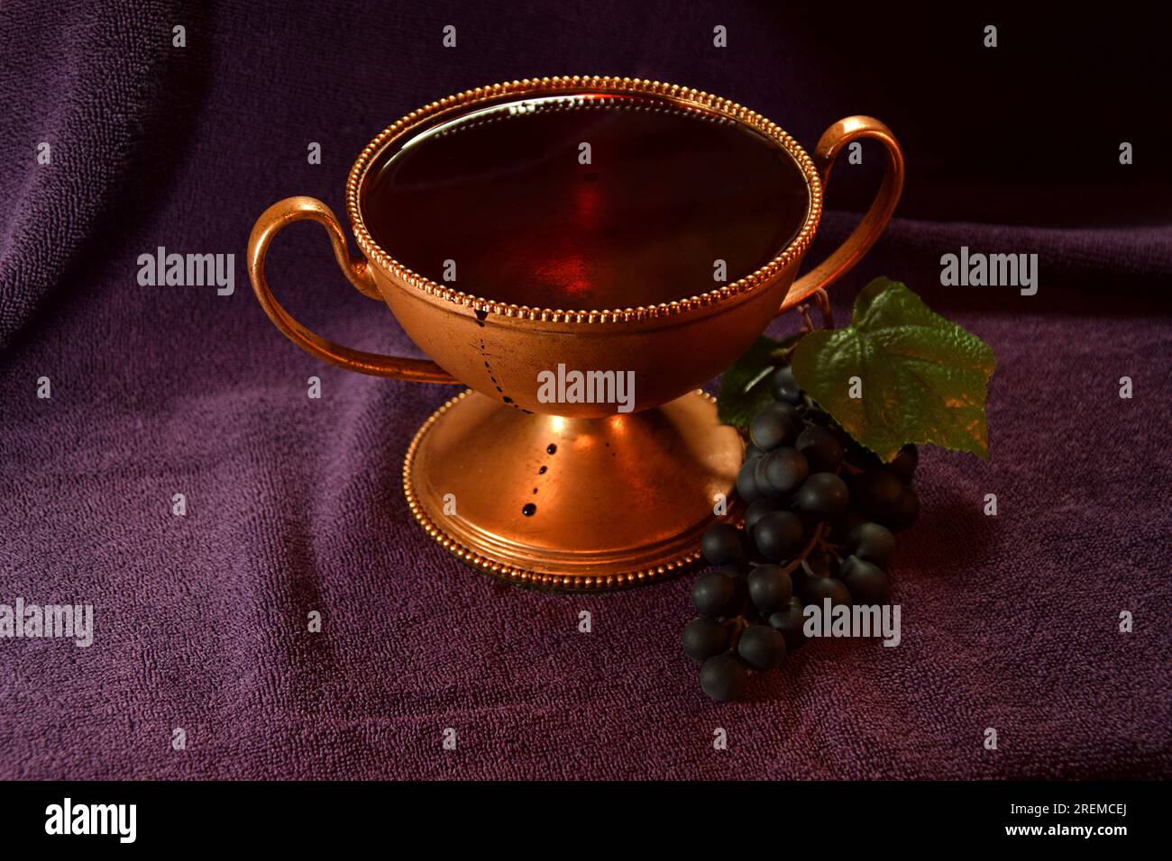 Golden colored chalice with Red liquid dripping down the side and ...