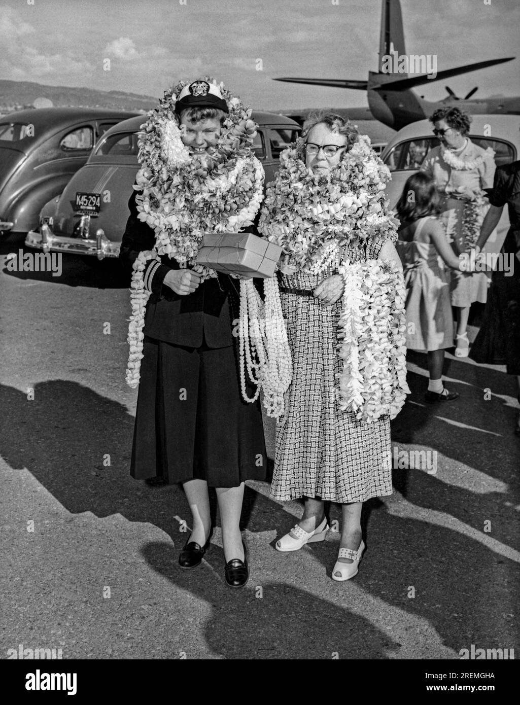 Hawaii: c. 1947. Two newly arrived women to Hawaii laden with leis and ...