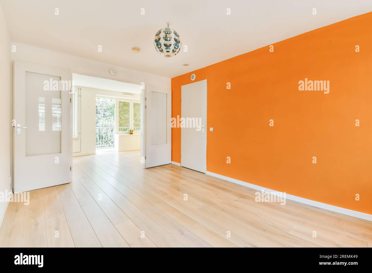 an empty living room with orange walls and hardwood flooring in the ...