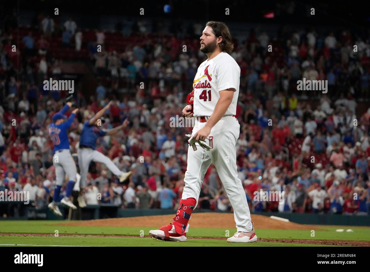 St. Louis Cardinals' Alec Burleson (41) walks off the field as members ...