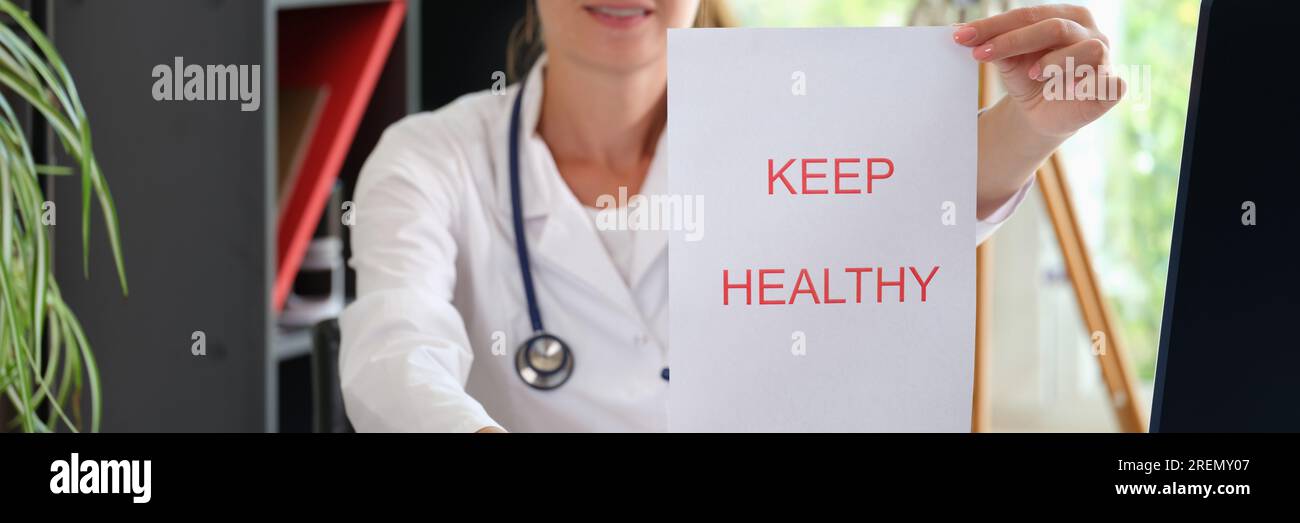 Female doctor showing paper with words keep healthy at her medical ...