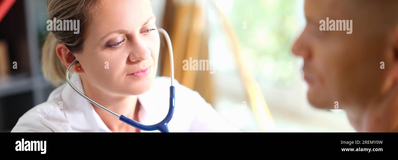 Female doctor with stethoscope doing medical examination of male ...