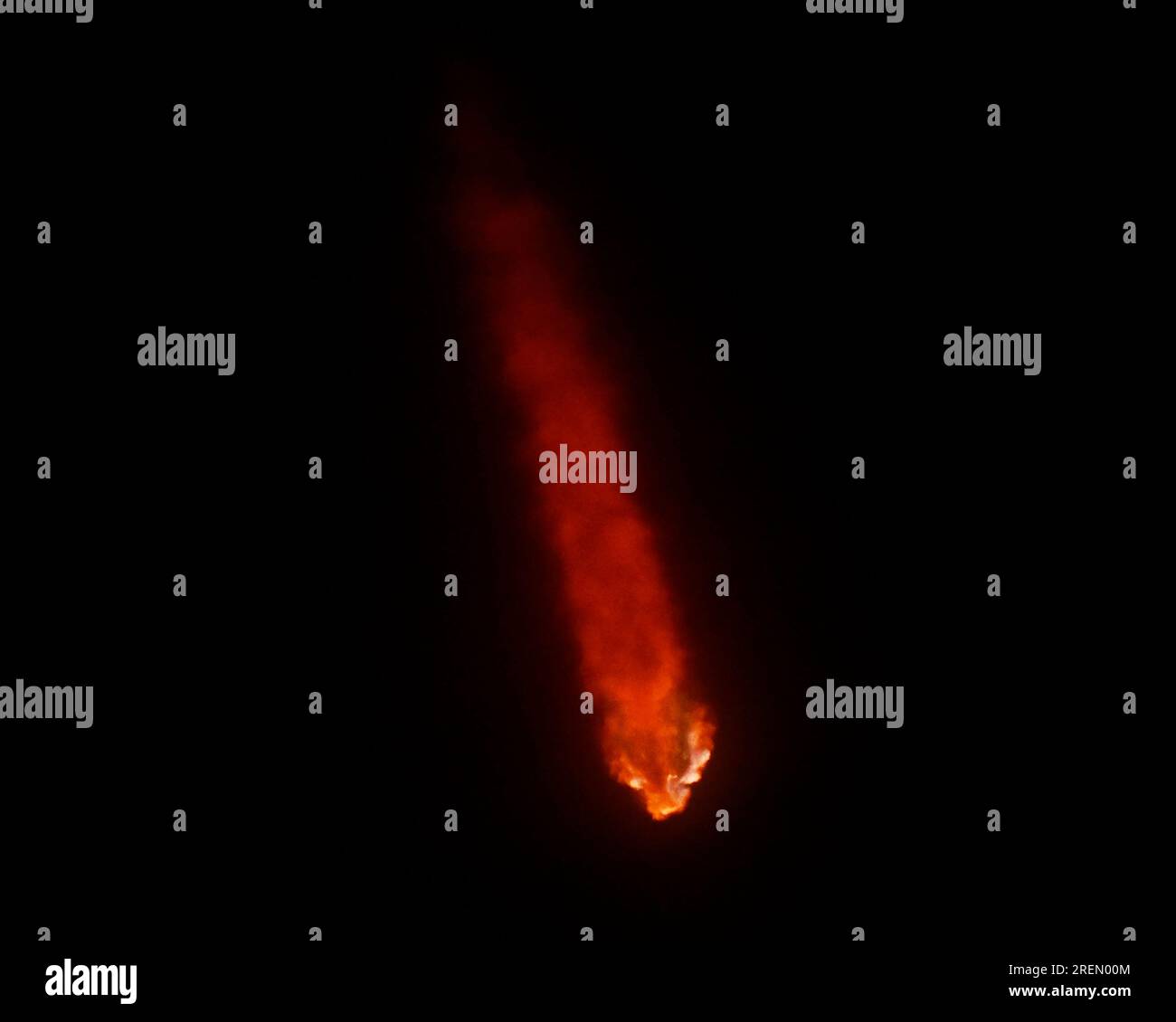 The exhaust plume of a SpaceX Falcon Heavy rocket glows red as it ...