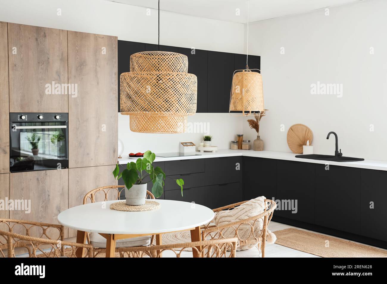 Interior of light kitchen with built-in oven, dining table and dark ...