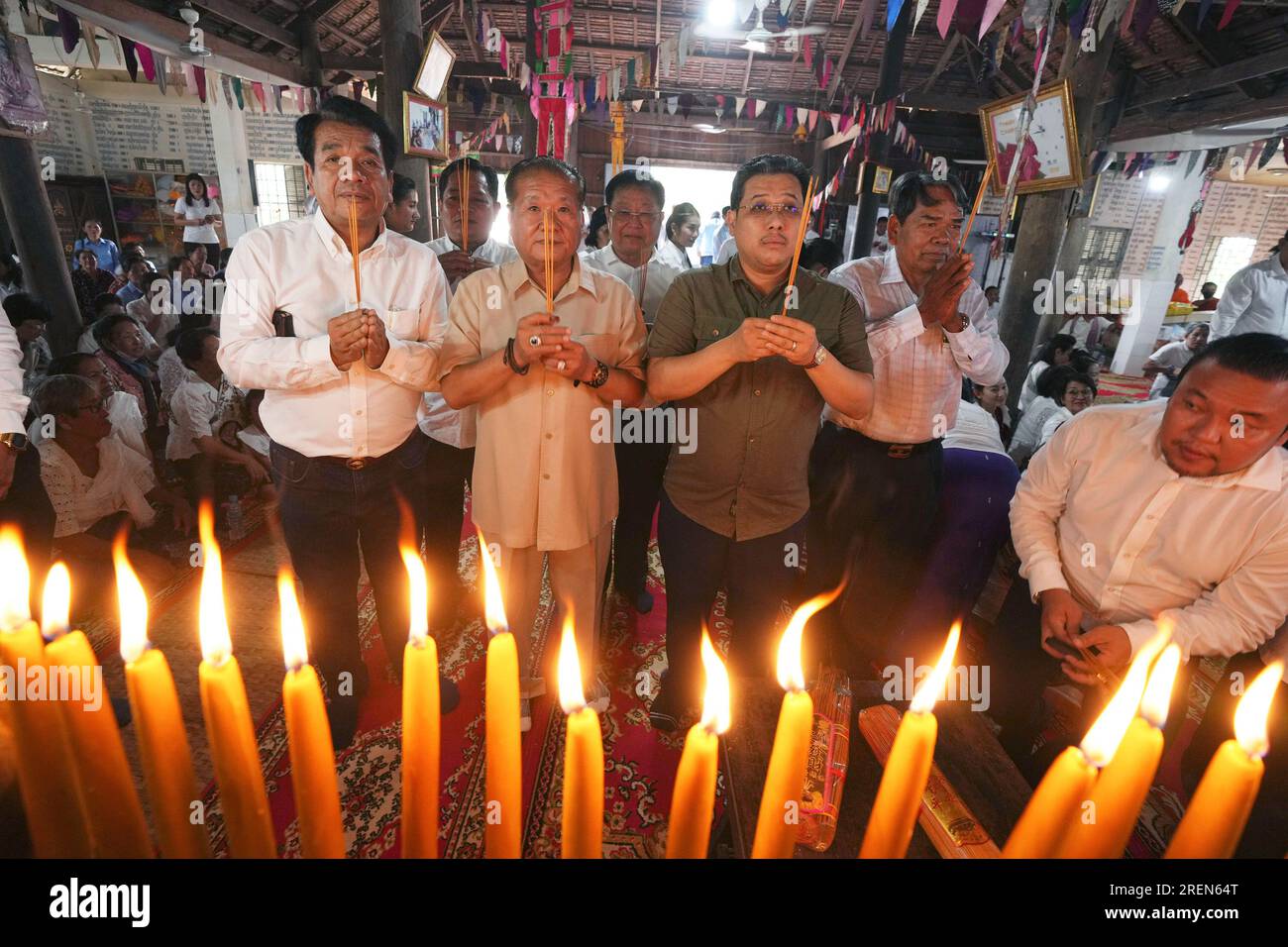 Cambodian Information Ministry officers offer prayers in front of lit ...