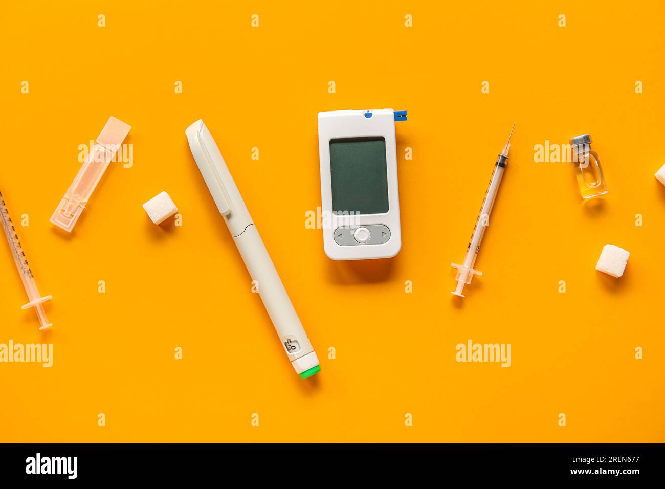 Glucometer with lancet pen, insulin and syringes on orange background ...