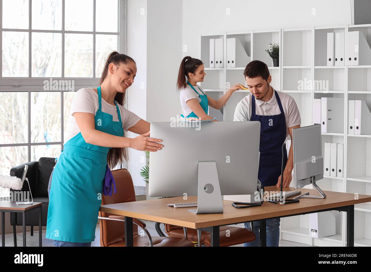 Young janitors cleaning workplace in office Stock Photo - Alamy