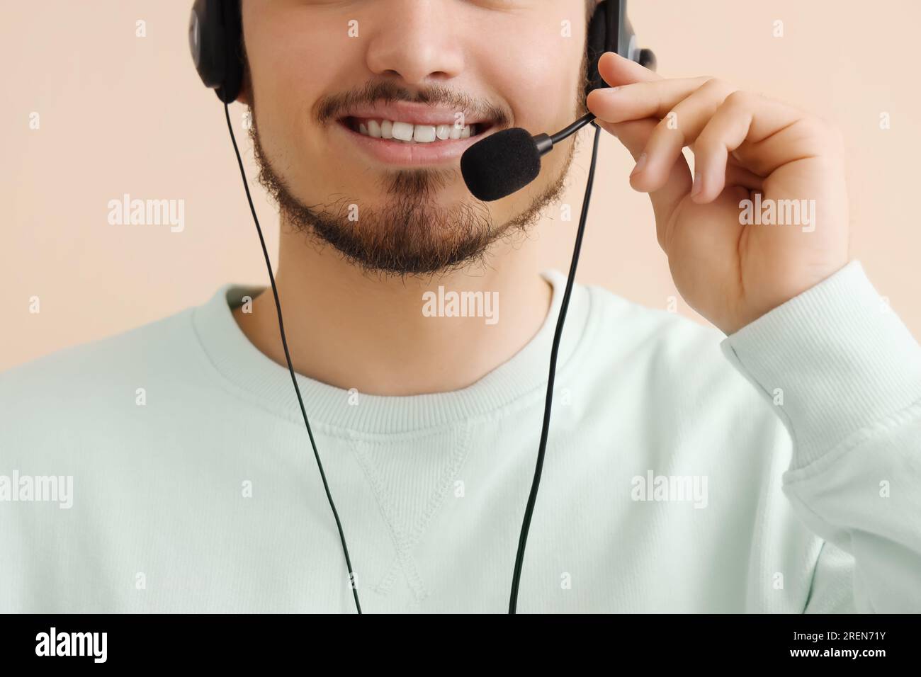Male technical support agent on beige background, closeup Stock Photo ...