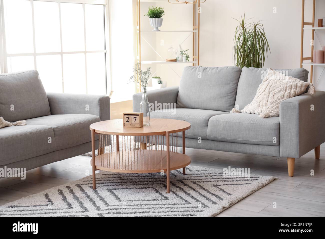 Interior of light living room with grey sofas, coffee table and large ...