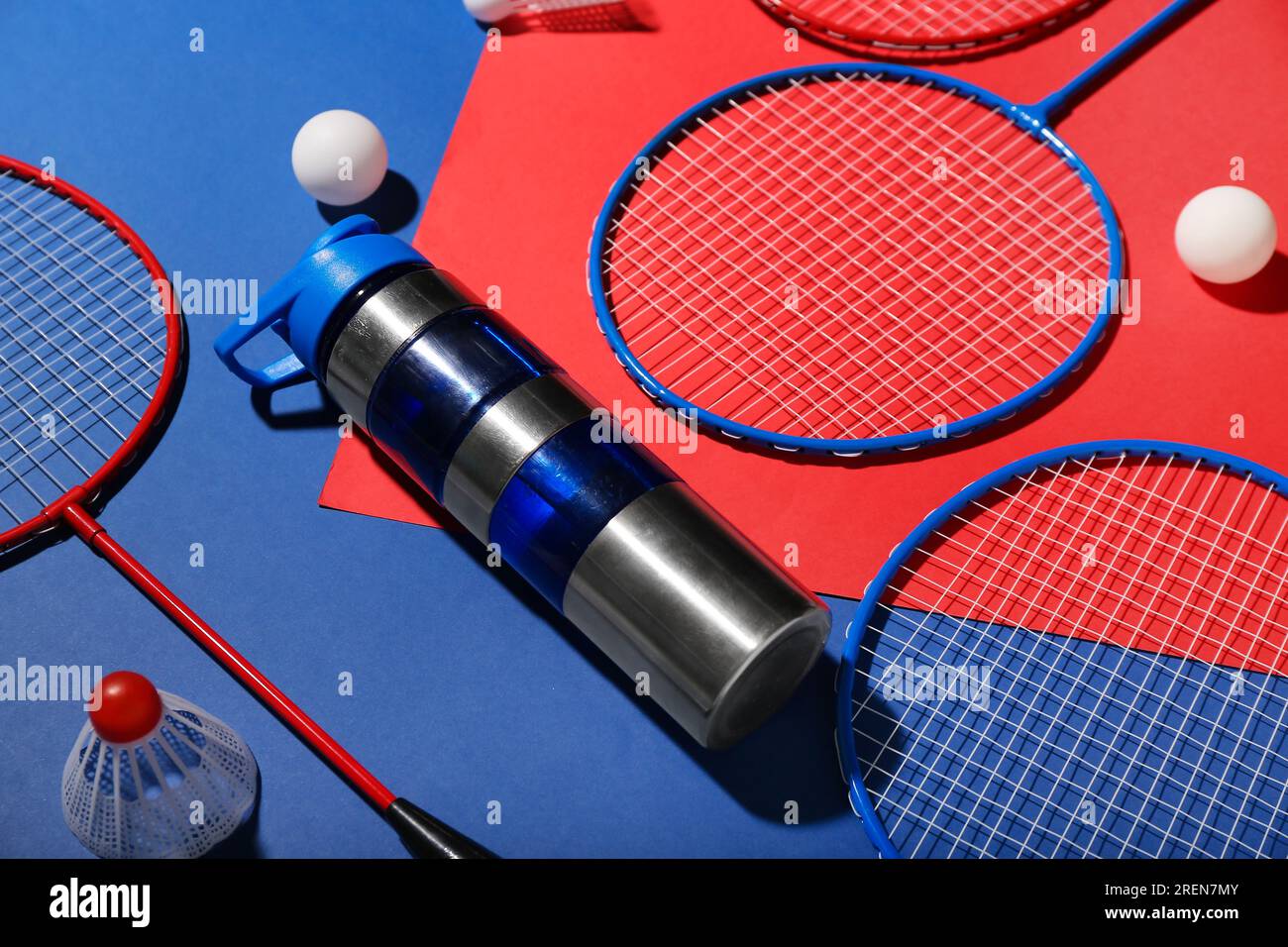 Composition with bottle of water, rackets, balls and shuttlecock on ...