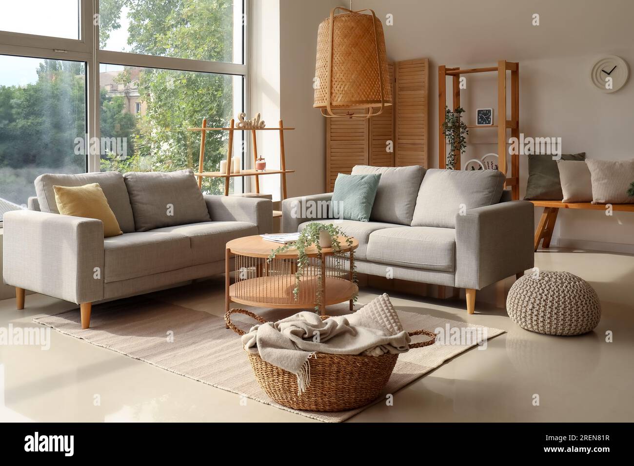 Interior of light living room with cozy grey sofas and wooden coffee ...