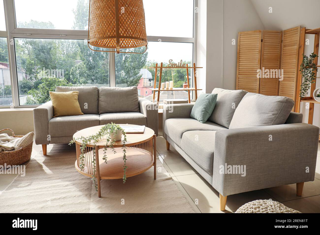 Interior of light living room with cozy grey sofas and wooden coffee ...