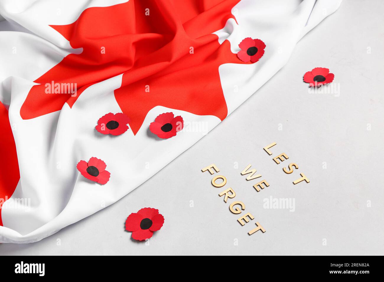 Poppy flowers with flag of Canada and text LEST WE FORGET on grey background. Remembrance Day ...
