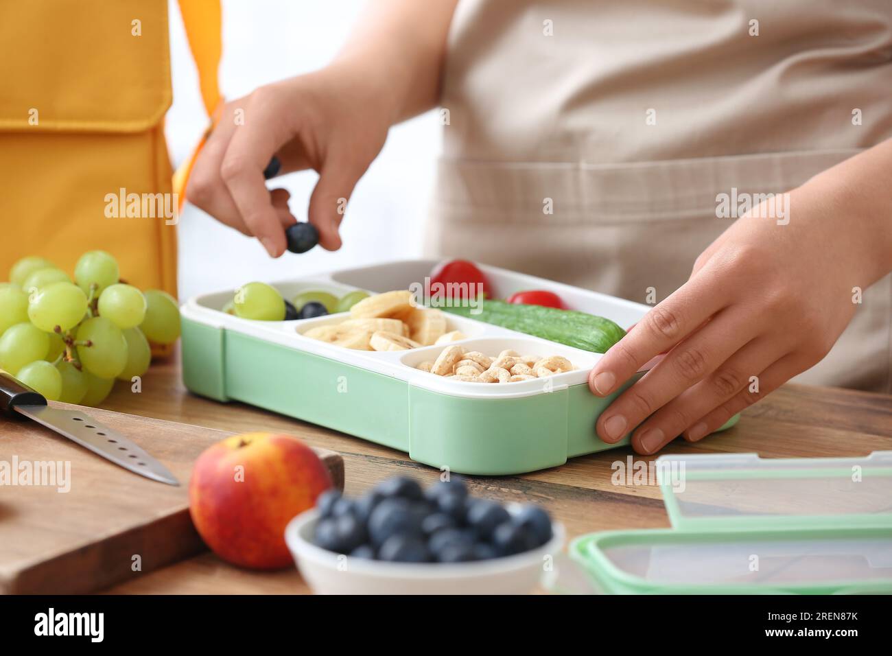 Woman packing fresh meal into lunch box in kitchen Stock Photo - Alamy