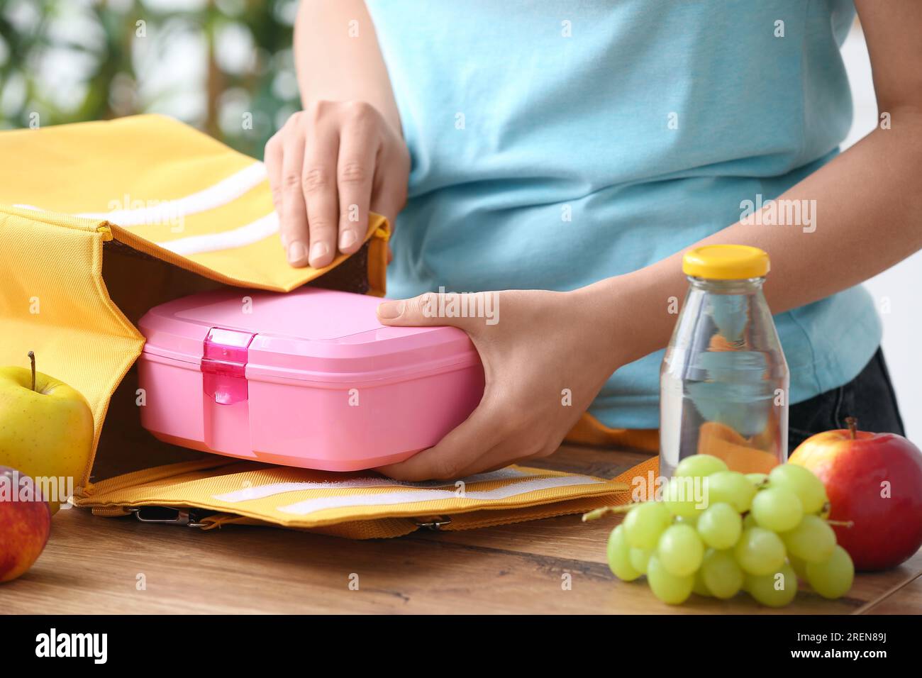 Woman packing fresh meal into lunch box bag in kitchen Stock Photo - Alamy