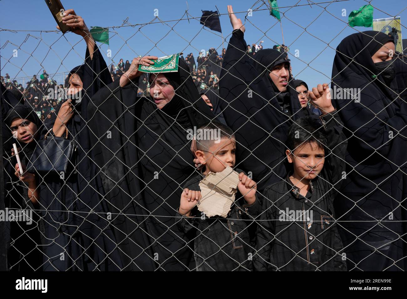 Women and children watch Shiite Muslims re-enact the seventh century ...