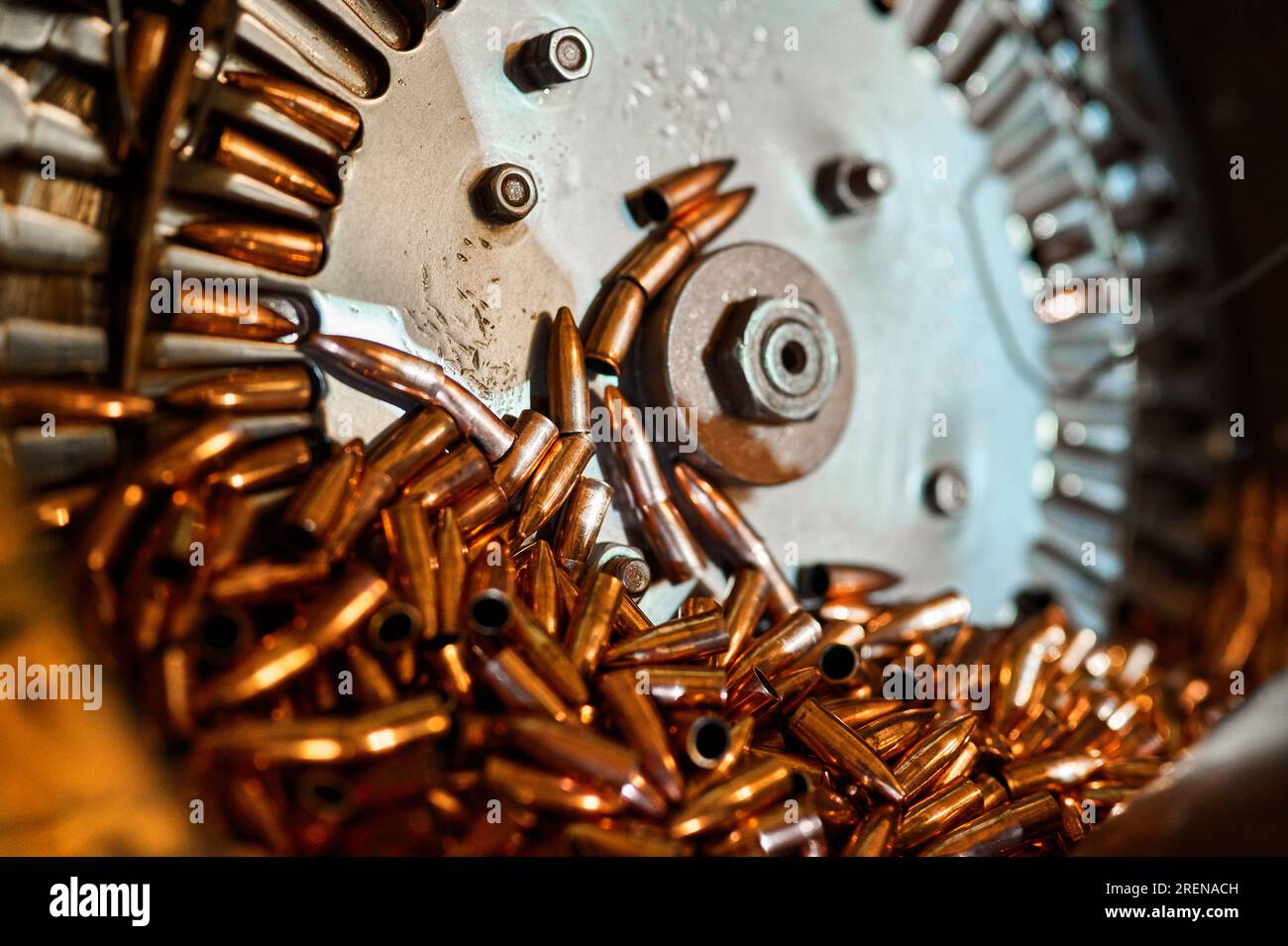 Pile of orange bullets and turning wheel at production line Stock Photo ...
