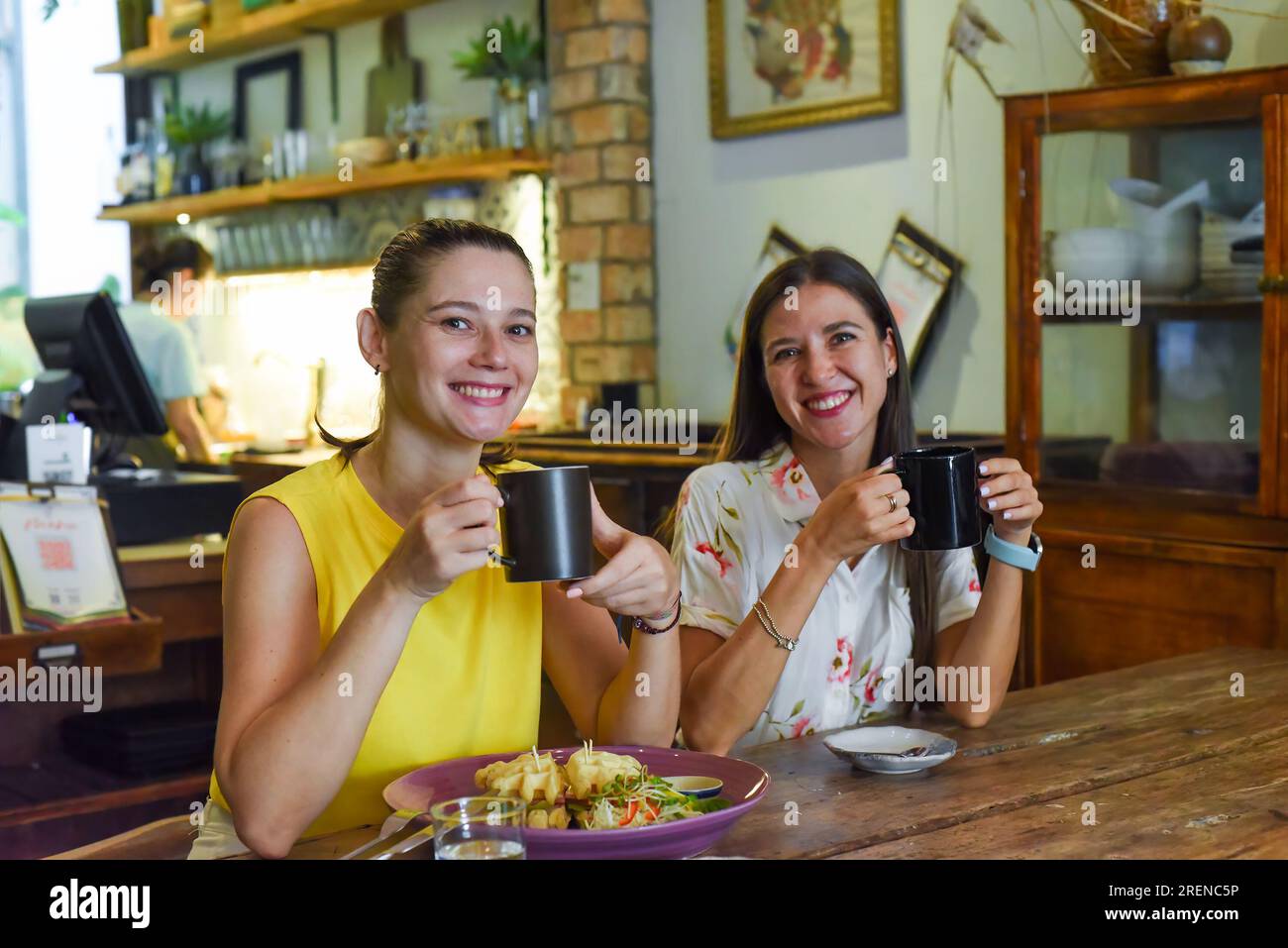 Two best friends talking and eating in a cafe Stock Photo - Alamy