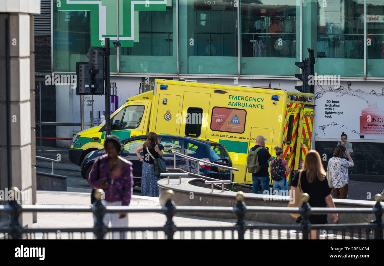 NHS Emergency Ambulance in traffic in a busy city, with blue lights ...