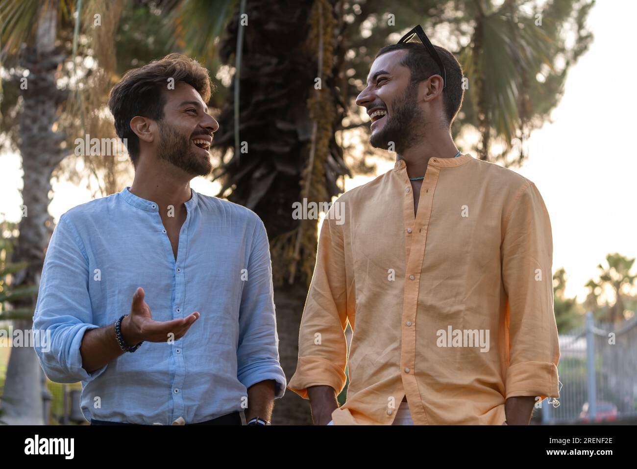 Two young men in their 30s have a spontaneous chat while strolling in a ...