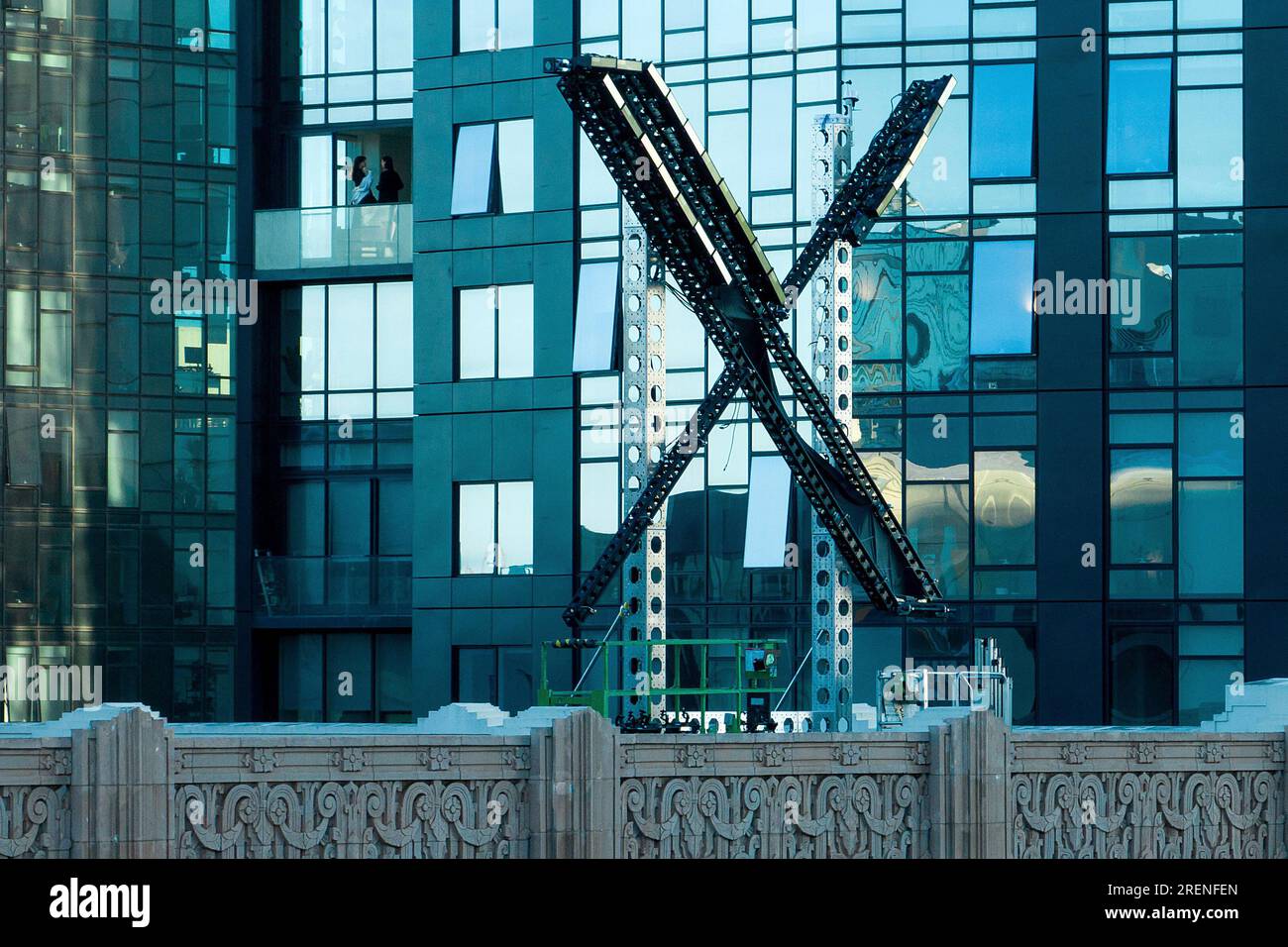 A partially completed "X" sign rests atop the company headquarters ...