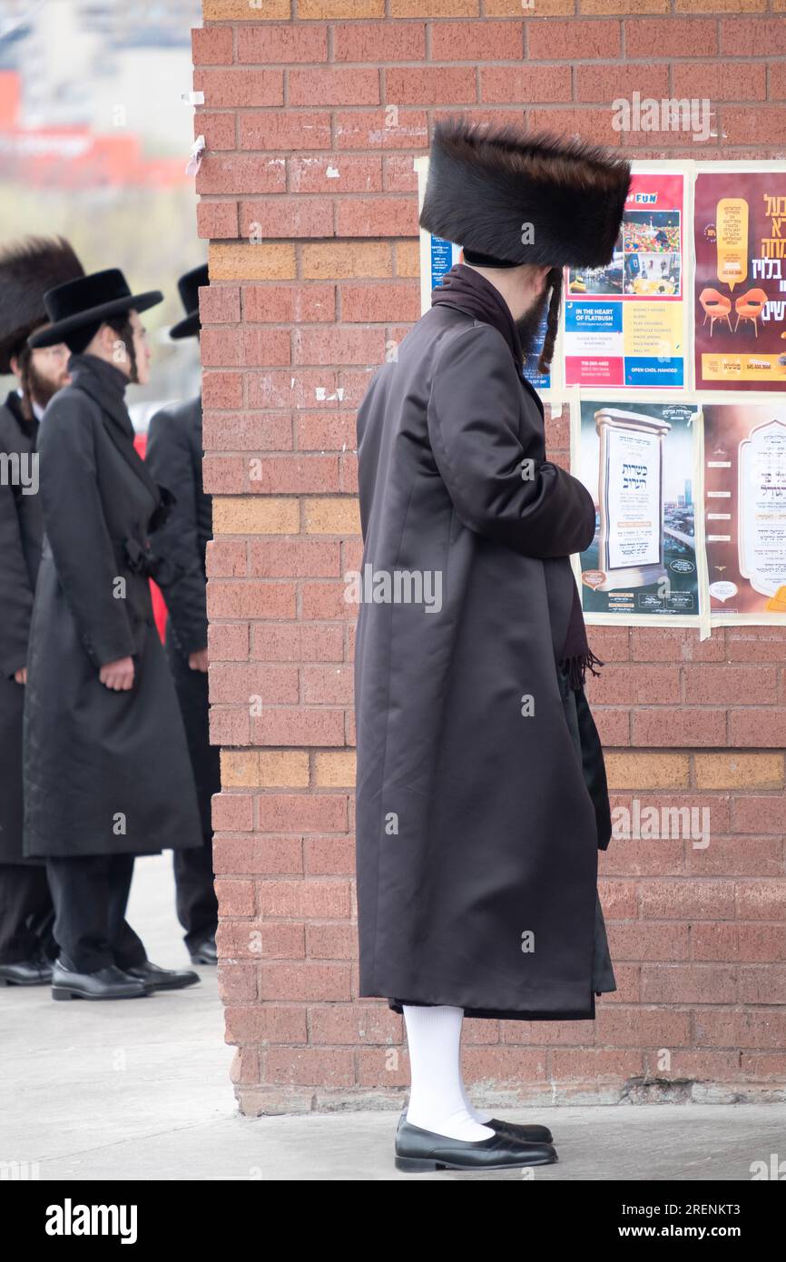 An orthodox Jewish man wearing a shtreimel fur had reads posters that ...
