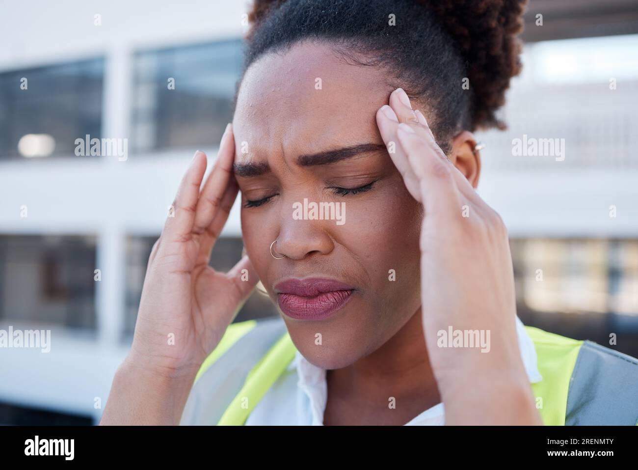 Face, sad and woman in construction with headache at renovation site ...