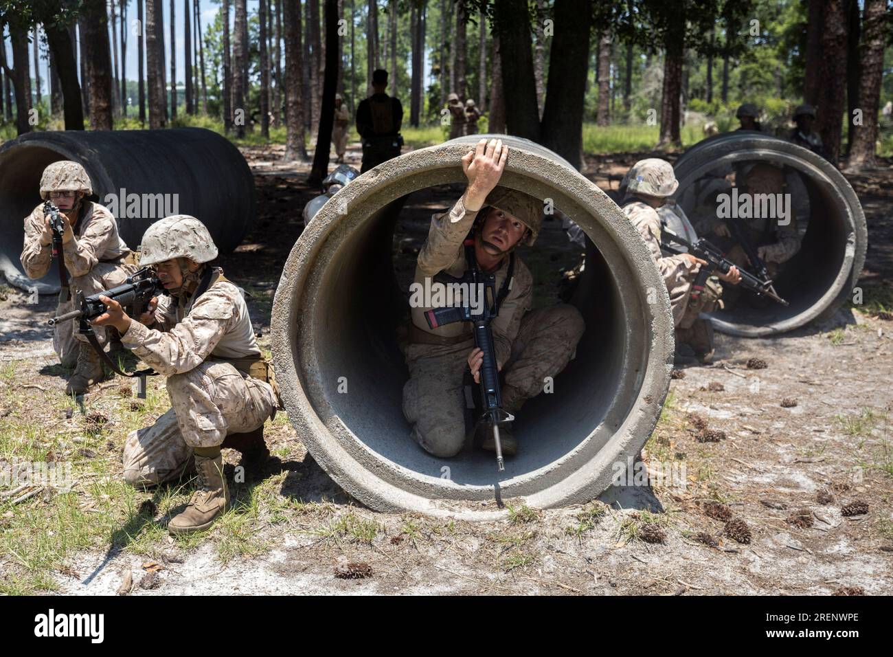 A U.S. Marine Corps recruit checks for a trip-wire around the edge of a ...