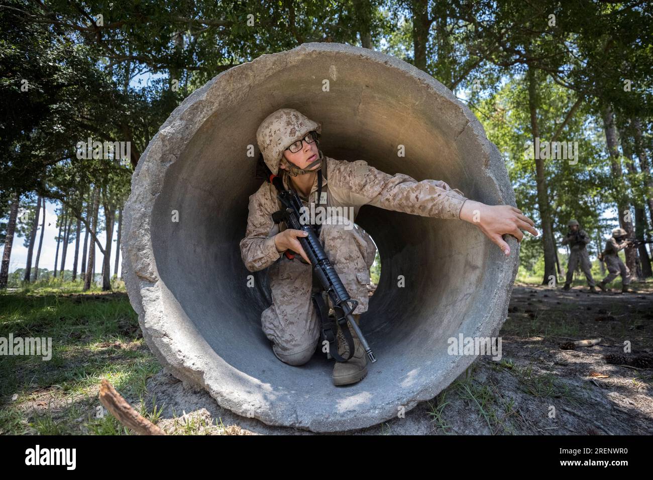 A U.S. Marine Corps recruit checks for a trip-wire around the edge of a ...