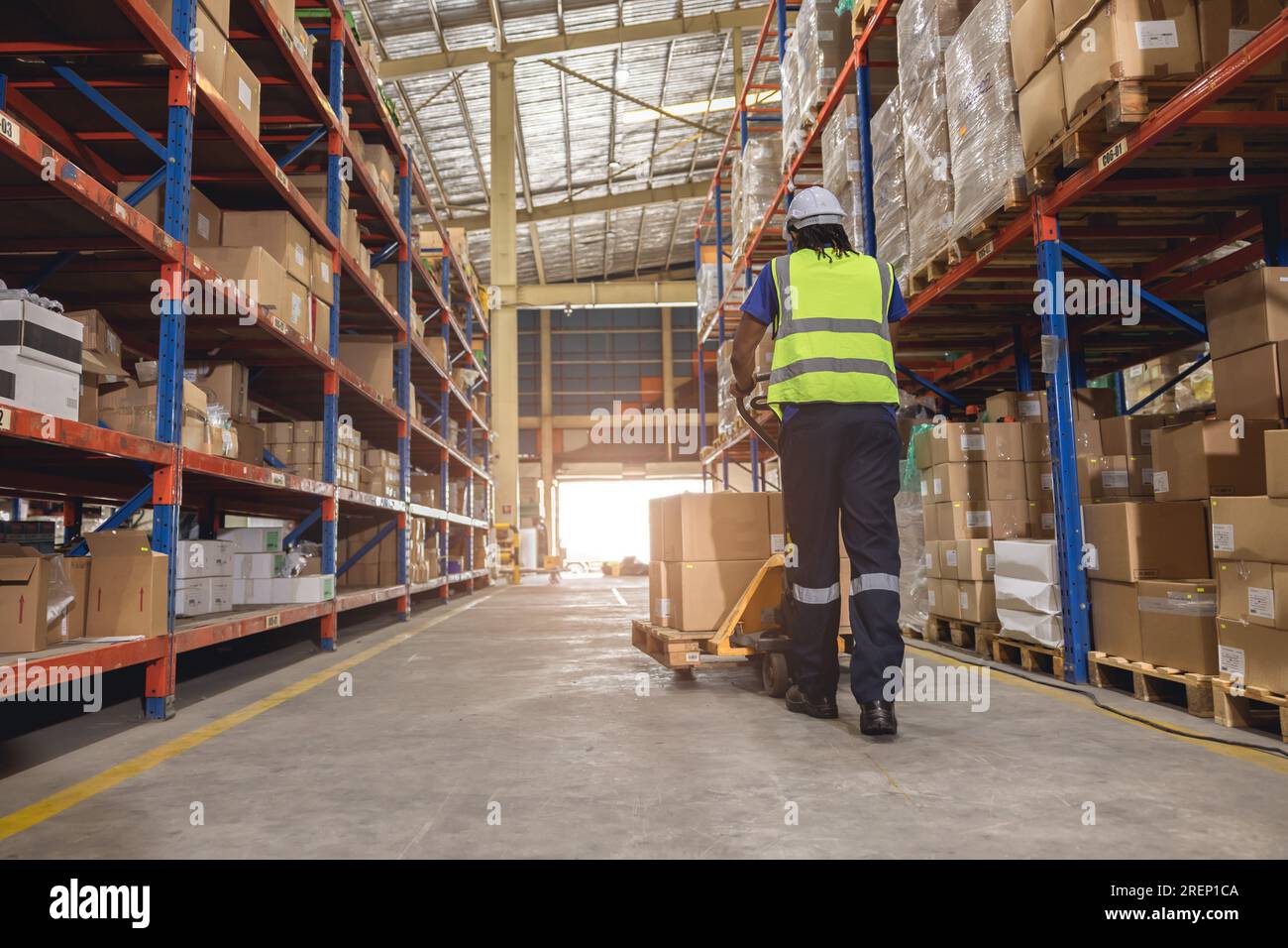 warehouse worker using hand pallet trucks loading cargo for shipping ...