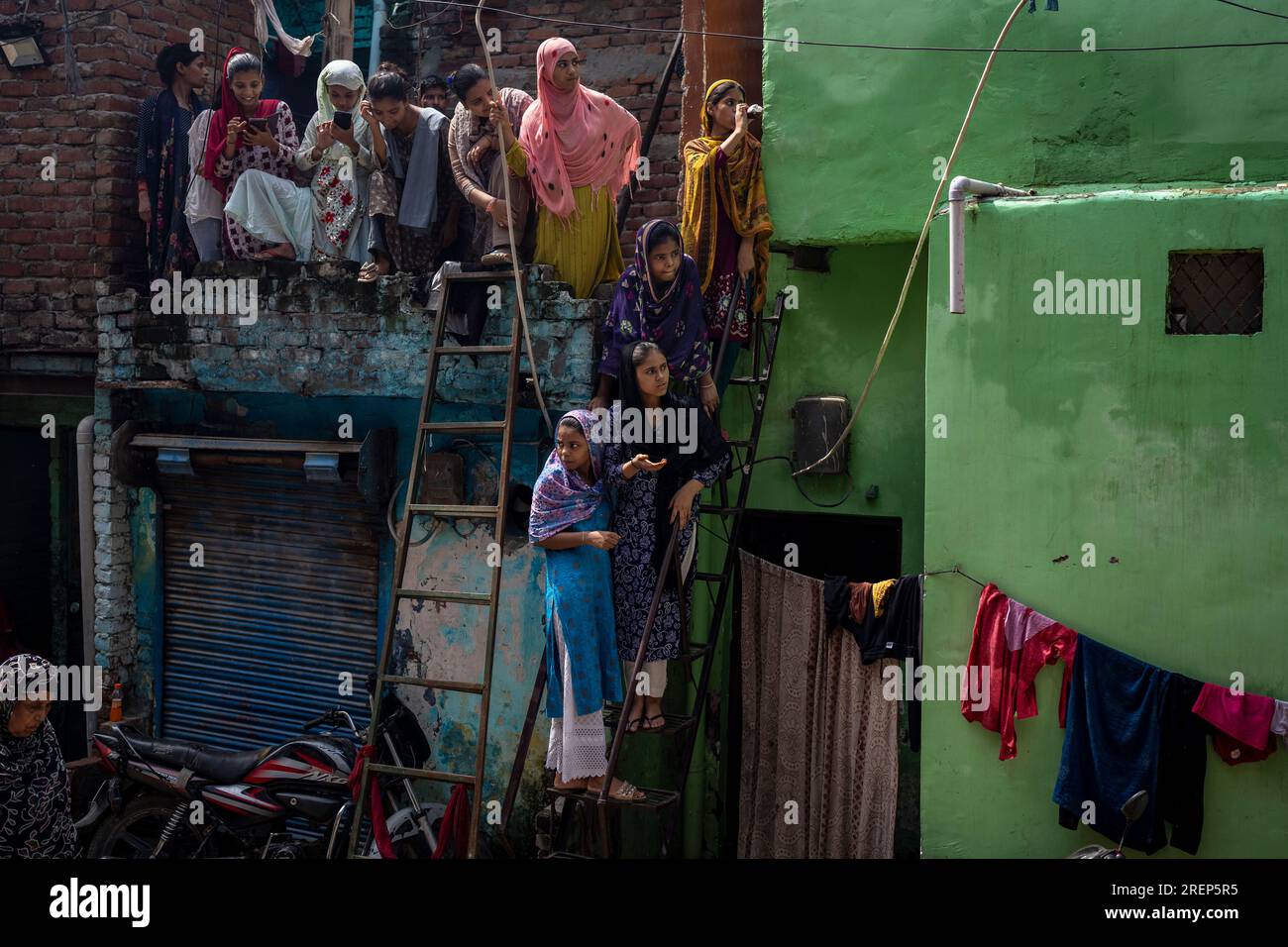 Women watch an Ashoura procession passing through an alleyway in New ...