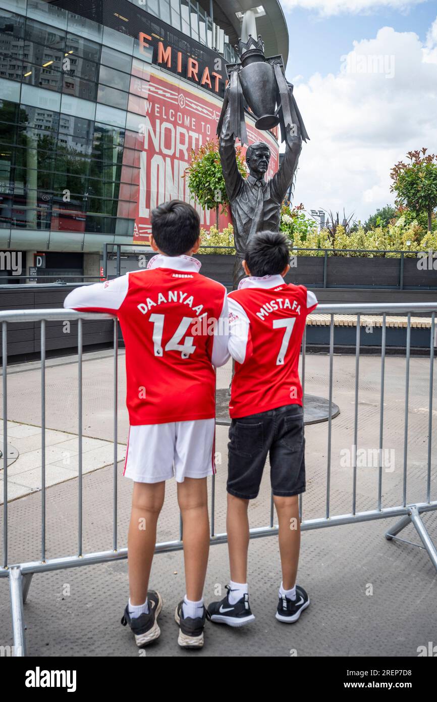 London, UK. 29 July 2023. Young fans view the statue of Arsenal manager ...