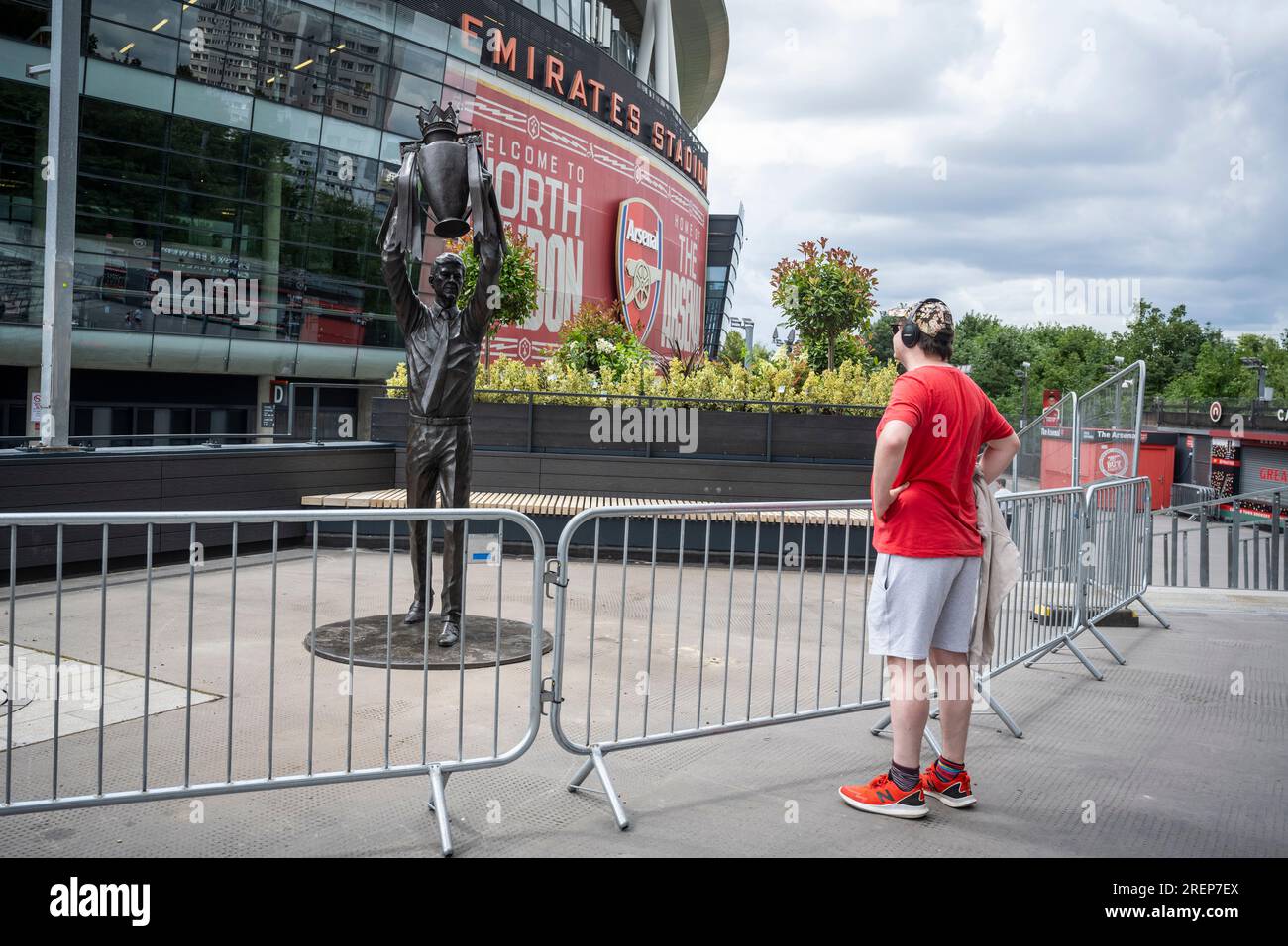 London, UK. 29 July 2023. A fan views the statue of Arsenal manager ...