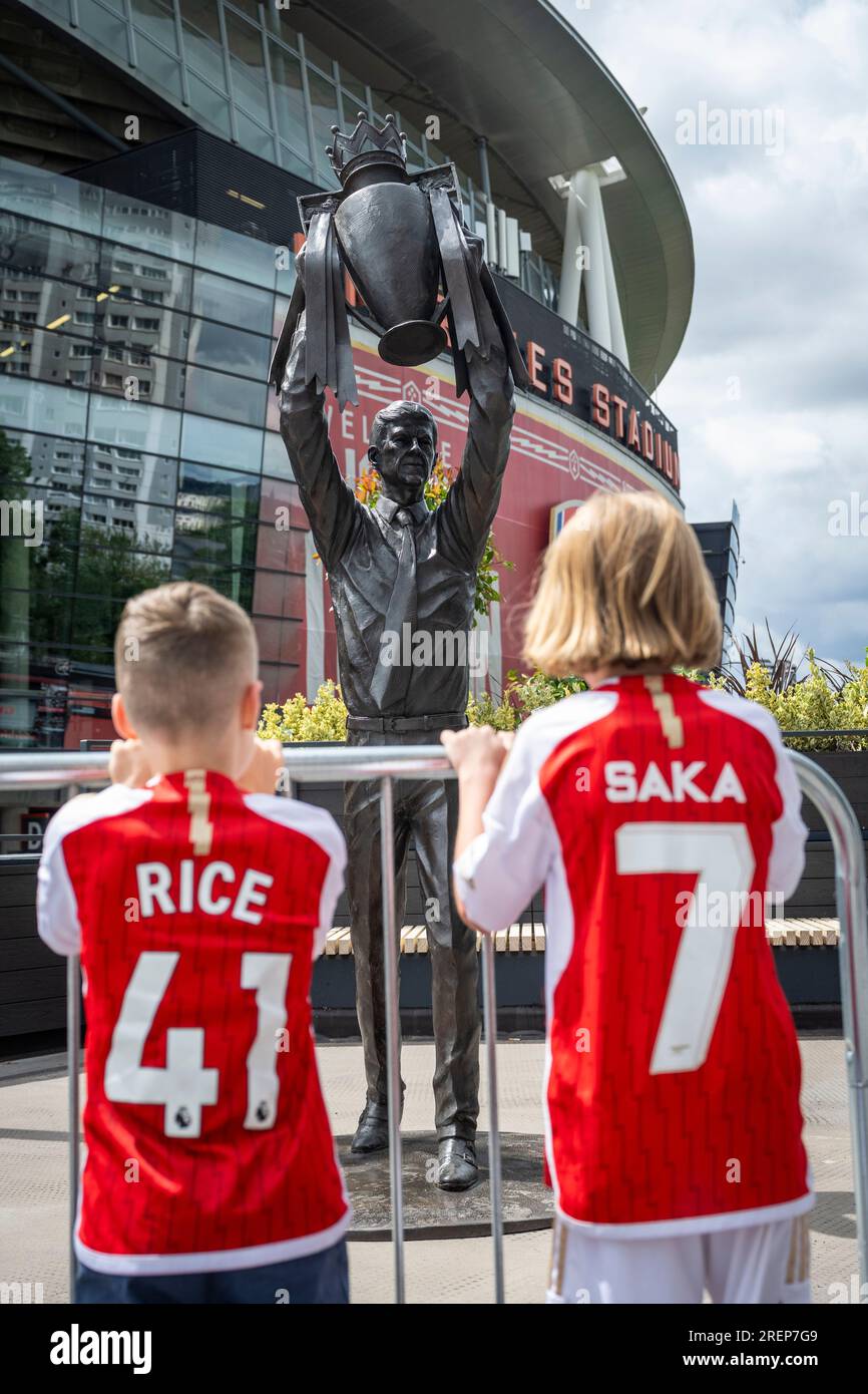 London, UK. 29 July 2023. Young fans view the statue of Arsenal manager ...