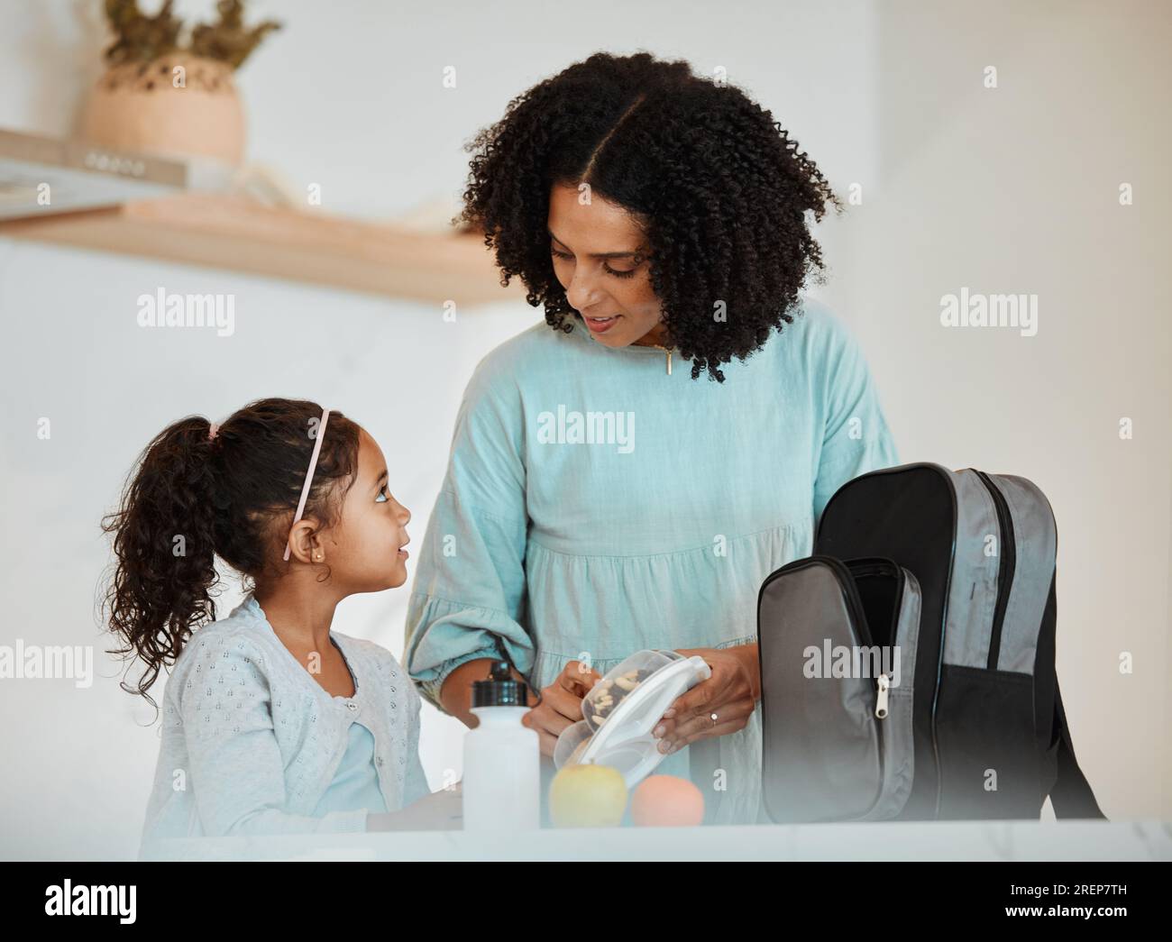 Mother packing lunch for her girl child for health, wellness snacks in ...