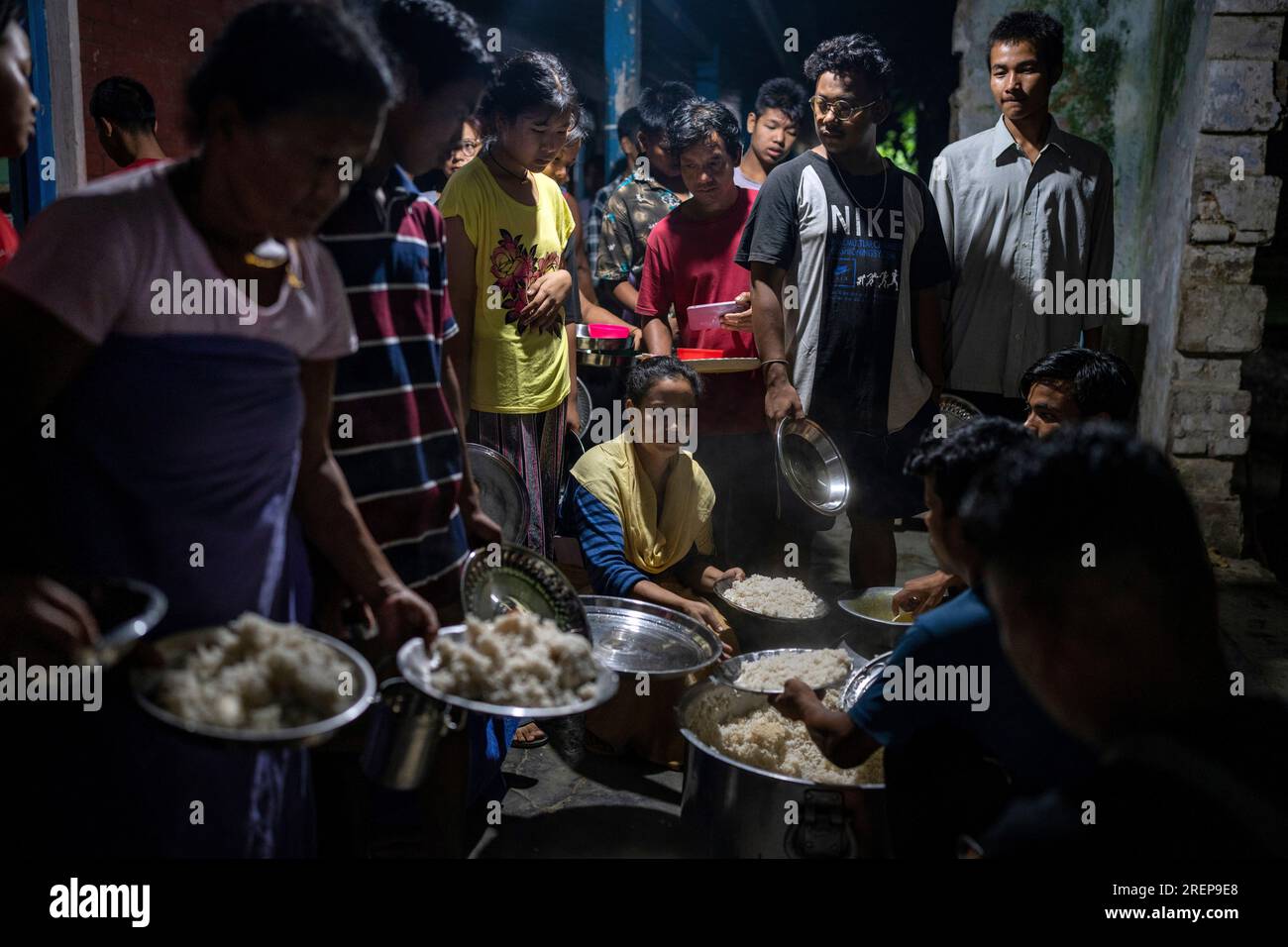 Displaced people from the Meitei community receive food at a relief ...