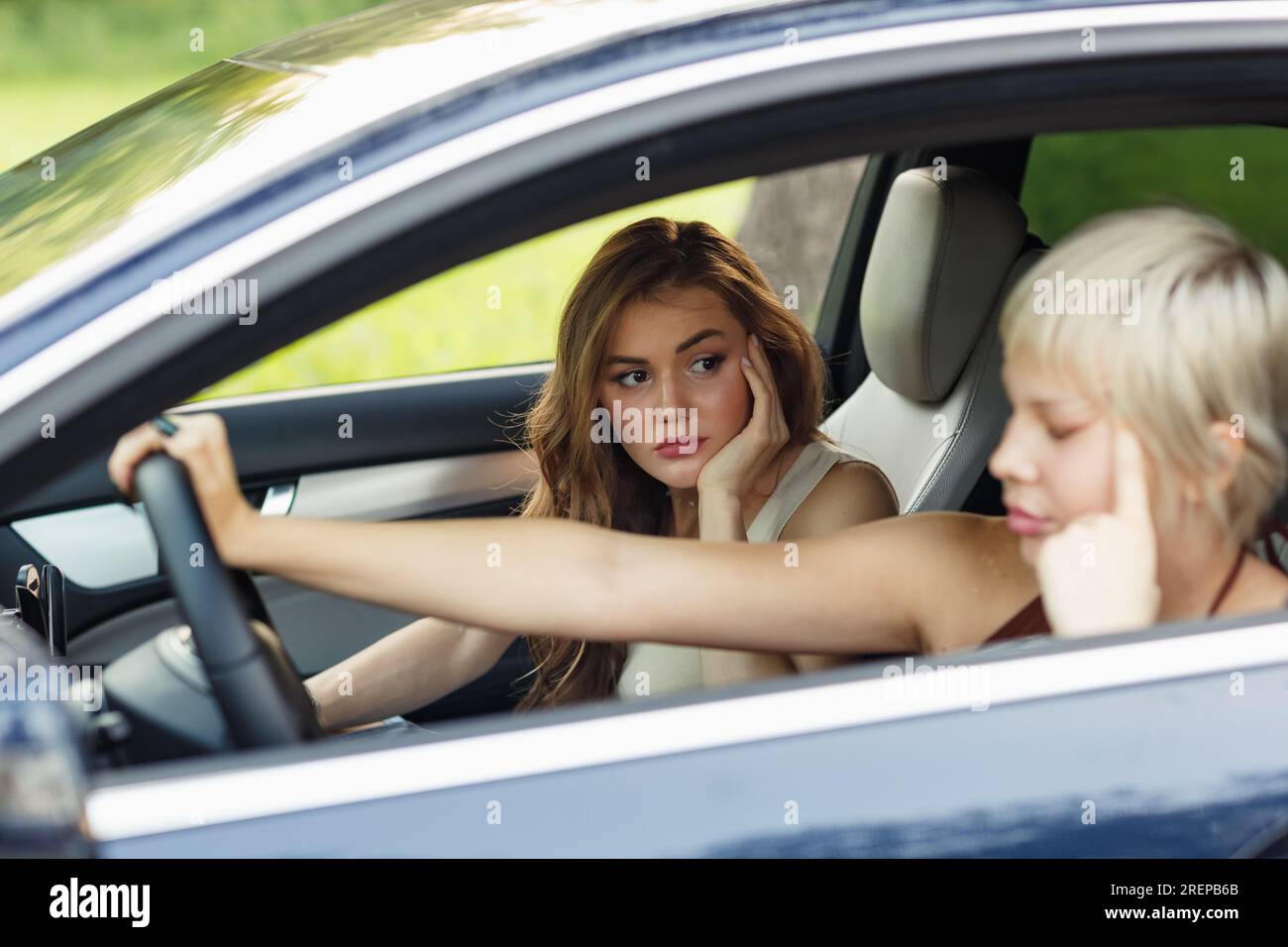 Two tired woman drivers at car smiling. Cute young happy female driving ...