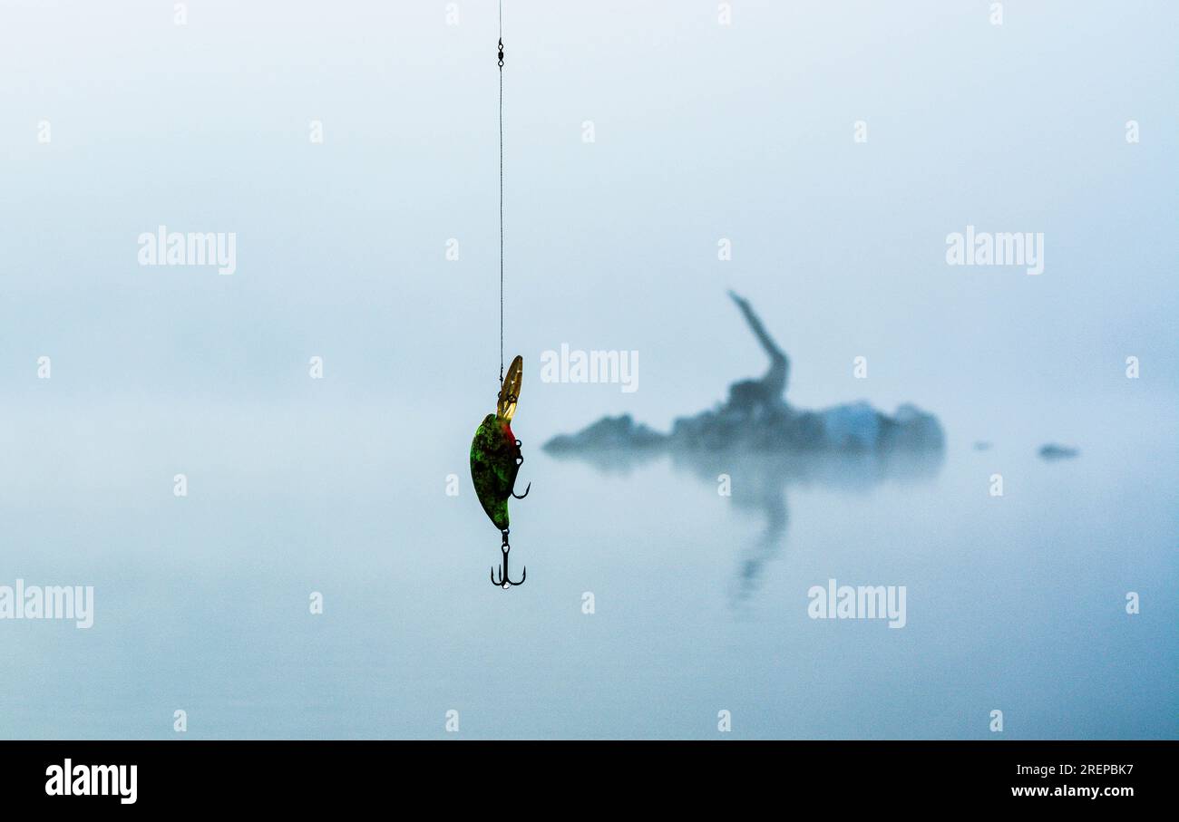 Morning fog fishing crank bait in silhouette with lake fog background ...