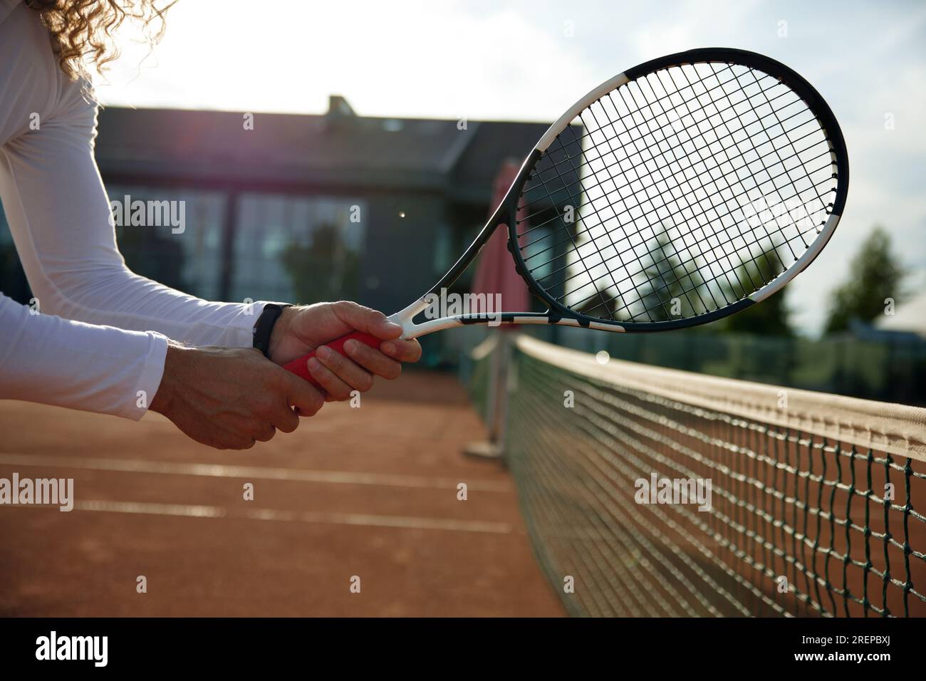 Closeup view of tennis player holding racket standing front of net ...