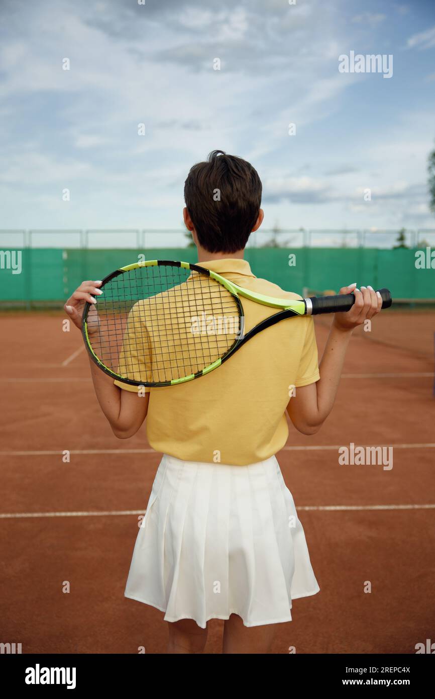 Back view on young teenage woman tennis player holding racket Stock ...