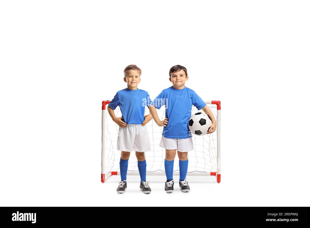 Little boys in football clothes posing in front of a mini goal isolated ...