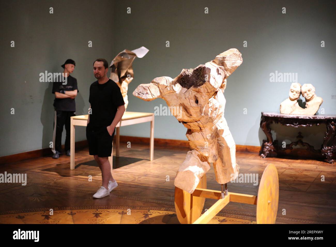 Visitors look at the wooden sculptures by the author Volodymyr Semkiv ...