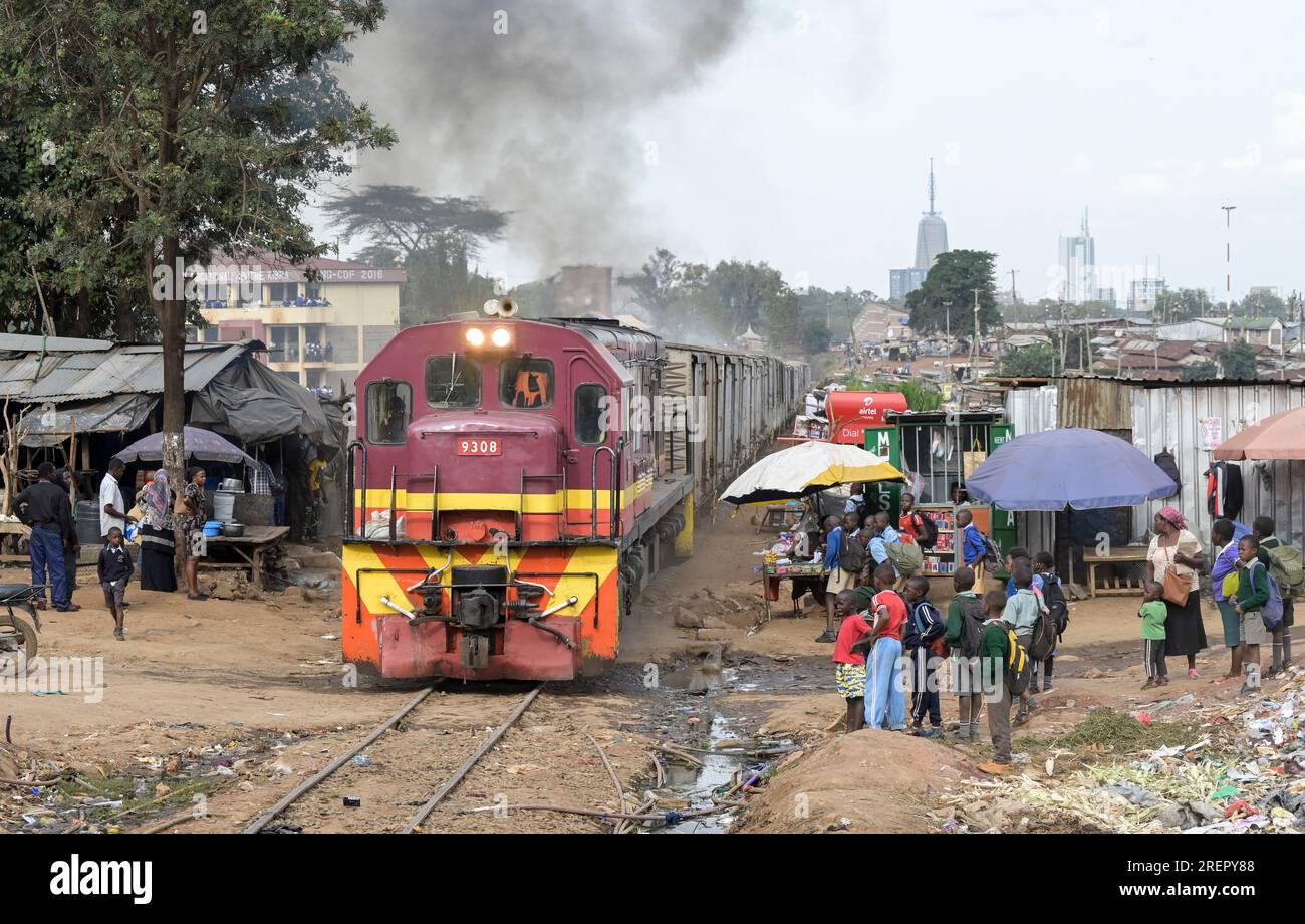 KENYA, Nairobi, Kibera slum, railway line, running freight train with ...