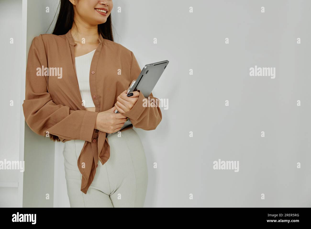 Unrecognizable smiling woman holding laptop isolated on white Stock ...