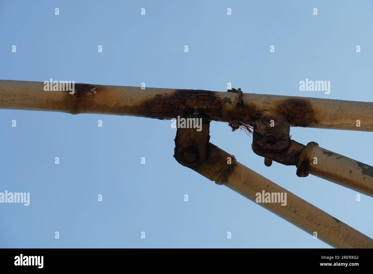 Very rusty piece of steel pipe with screws and bolts painted white ...