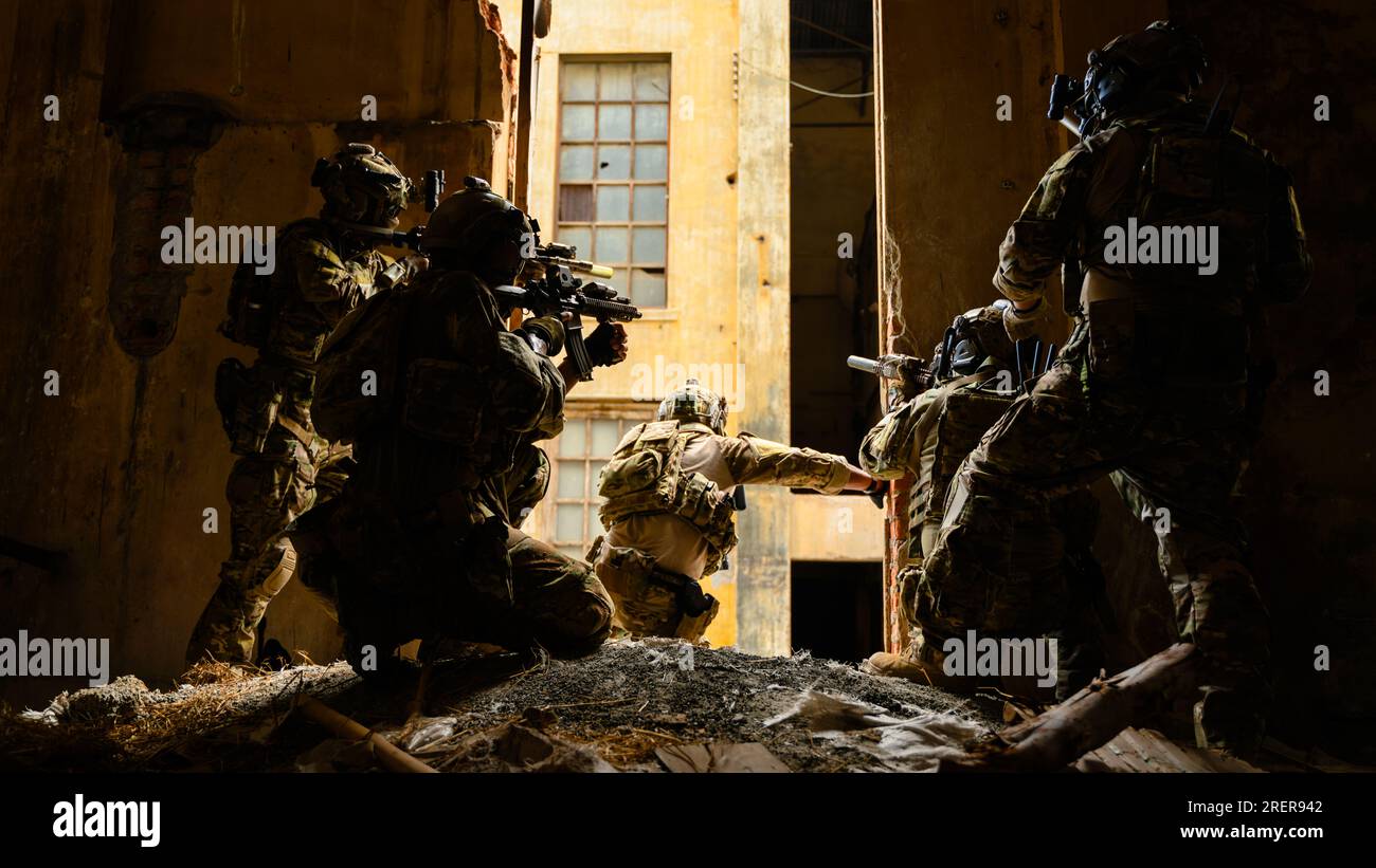 Expert team of soldiers with weapons attacking enemy during military ...