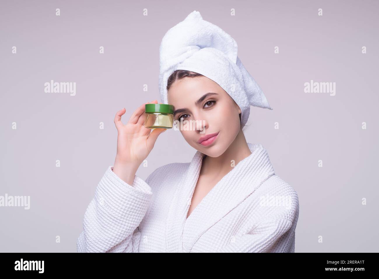 Young woman applying body cream against studio background. Beauty ...