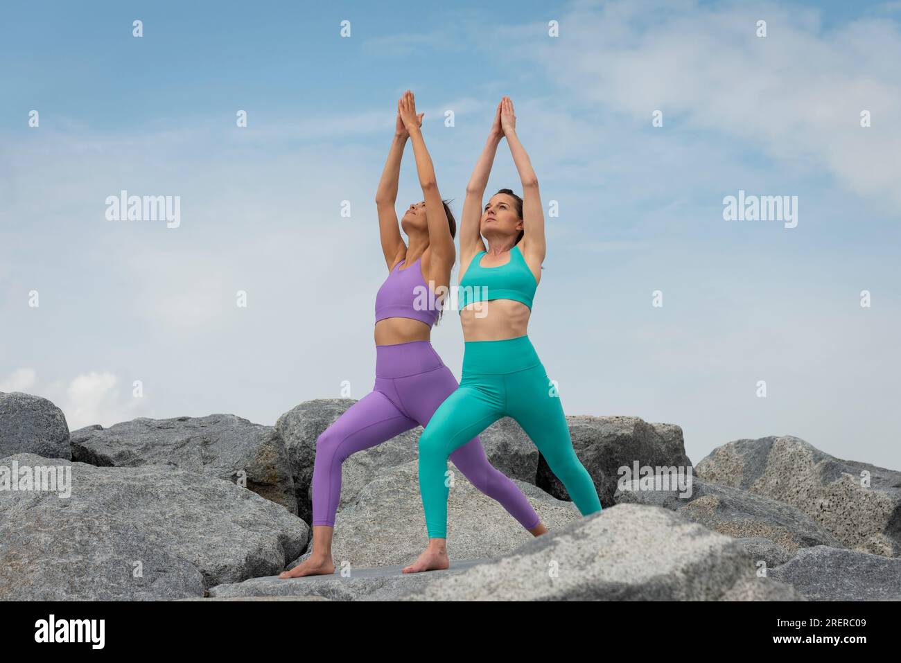 Two women practising yoga outside. High lunge pose Stock Photo - Alamy
