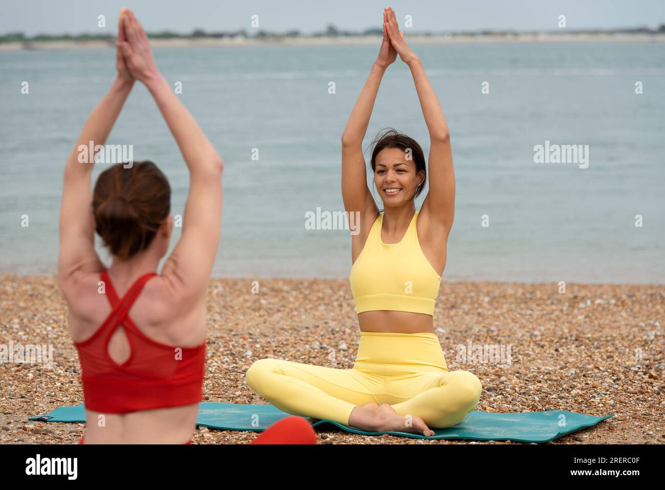 Yoga meditation class on the beach. Two women Stock Photo - Alamy