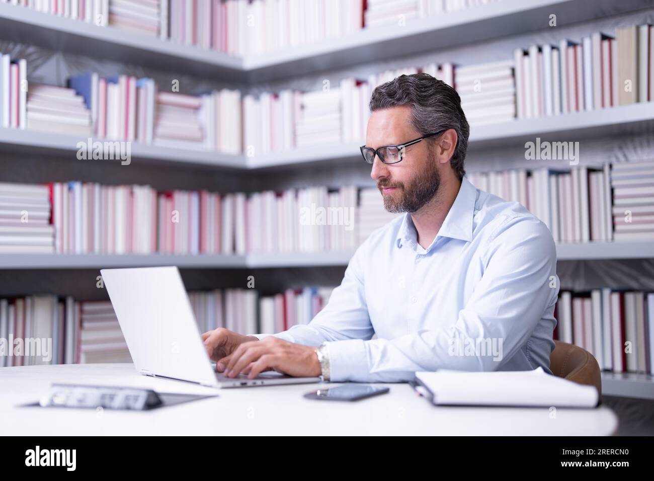 Portrait of hispanic business man in library. Handsome business man in ...